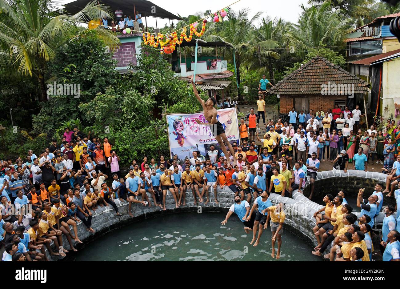 Mumbai, India. 27th Aug, 2024. A devotee leaps in air to break a pot ...