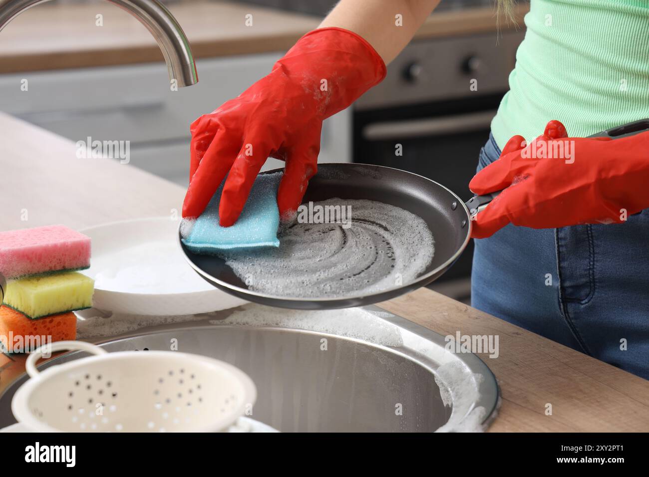 Woman wash frying pan hi-res stock photography and images - Alamy