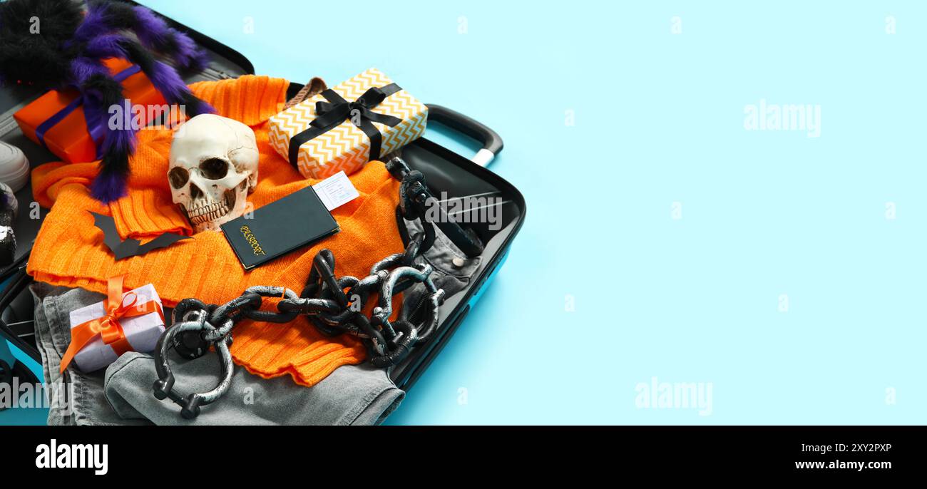 Open suitcase with clothes, different Halloween decorations and gift ...