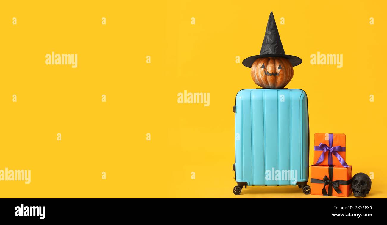 Suitcase and different Halloween decorations on yellow background with ...