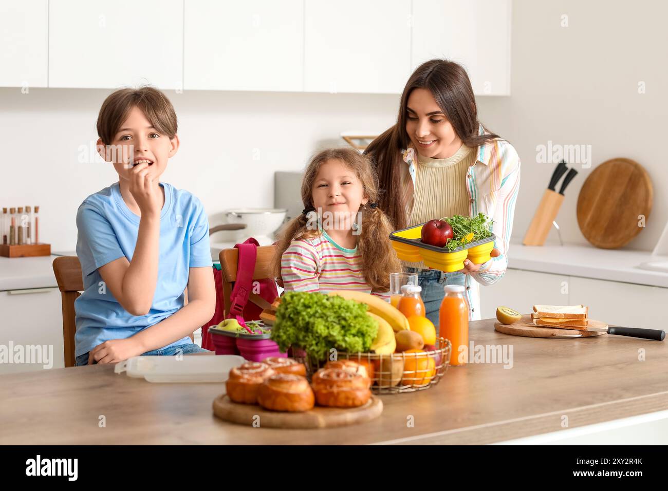 Mother packing school lunch for her little children in kitchen Stock ...