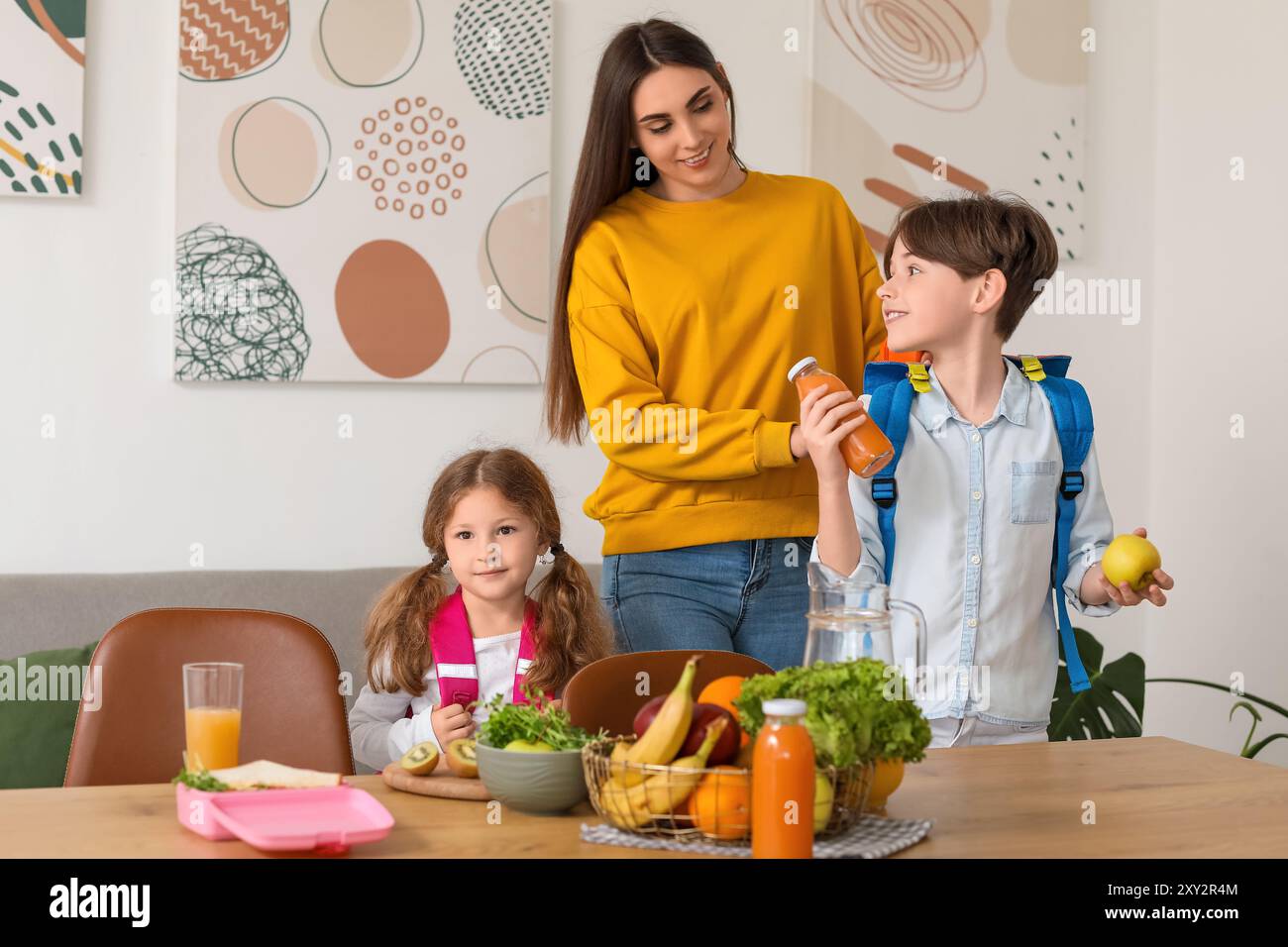 Mother packing school lunch for her little children in kitchen Stock ...