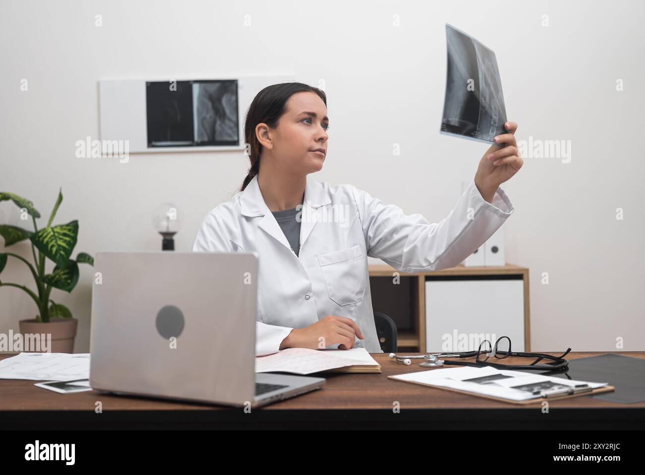 doctor examines a patient's X-ray film, while a radiologist carefully ...