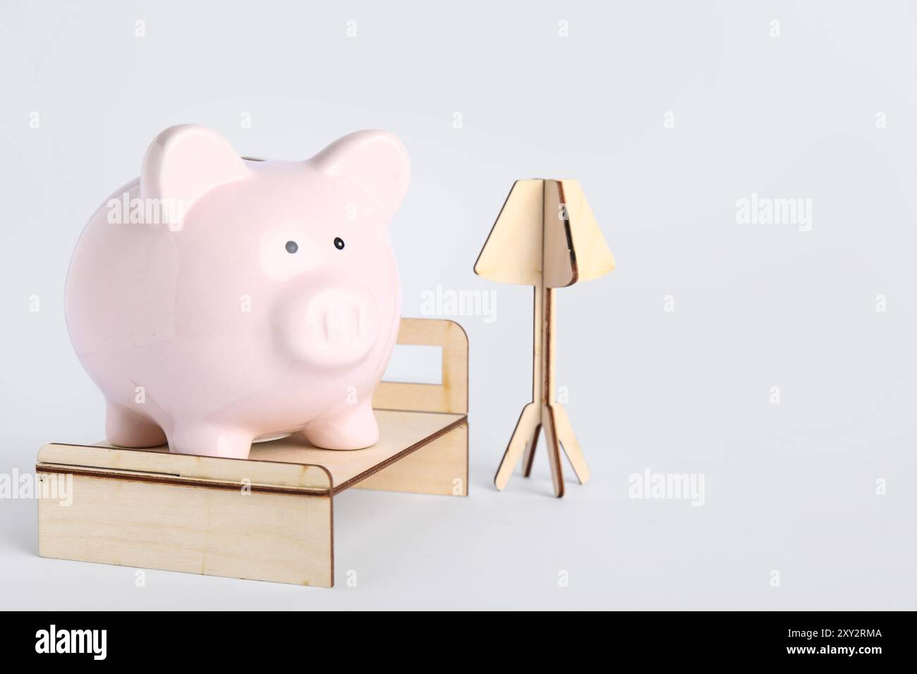 Piggy bank with wooden miniature furniture on white background Stock ...