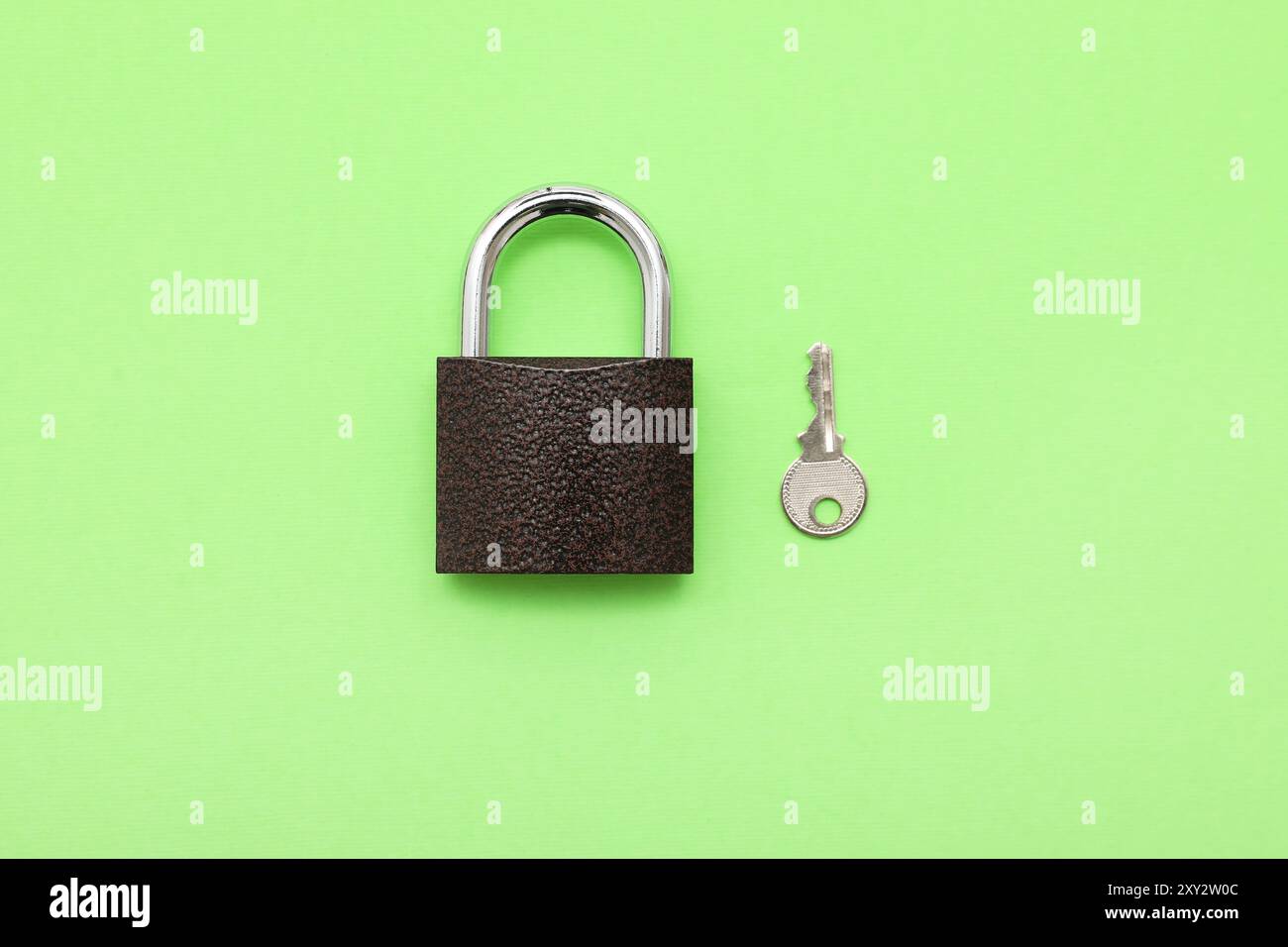 Padlock with key on green background Stock Photo - Alamy
