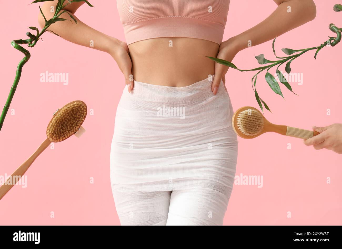 Young woman in anti-cellulite bandage with massage brushes and bamboo ...