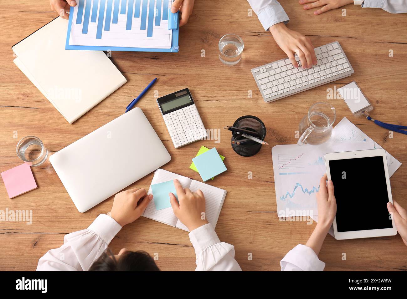 Business team working with diagrams and tablet during meeting in office ...