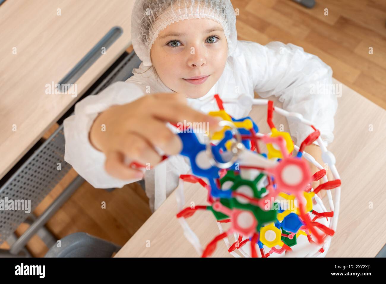 A little pre-teenage girl learns a 3D model of DNA in a science ...
