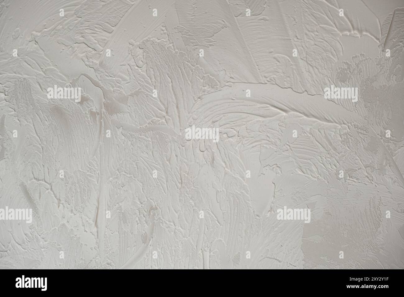 Applying decorative putty. White abstract texture of surface covered ...
