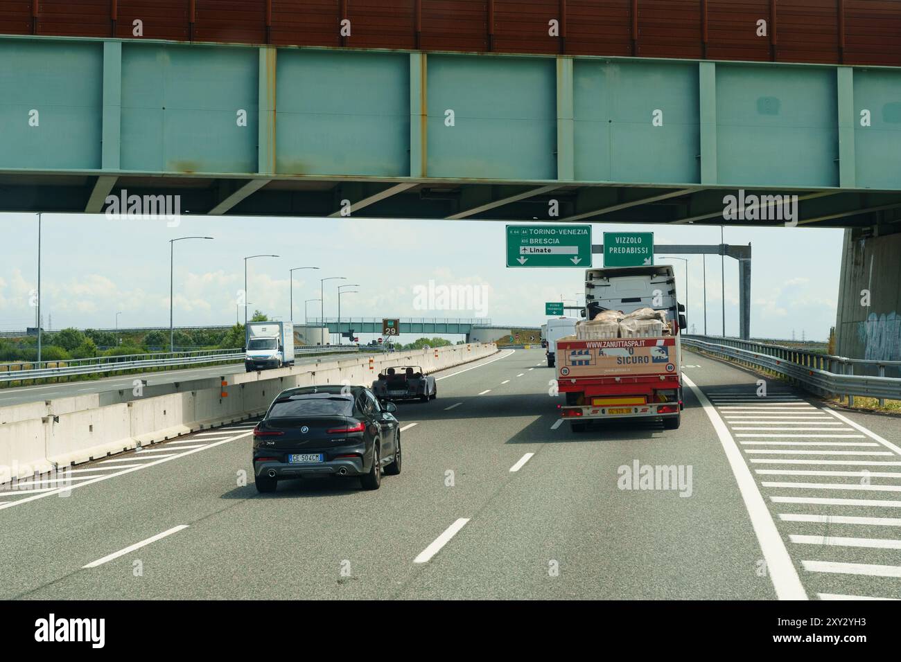Riozzo, Italy - June 7, 2023: Cars and a truck navigate an active ...