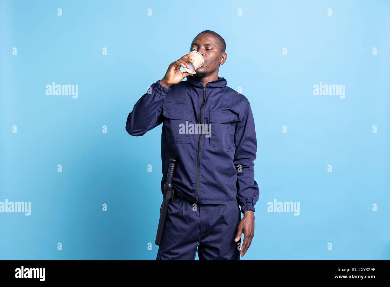 Portrait of african american security guard serves coffee cup in studio ...