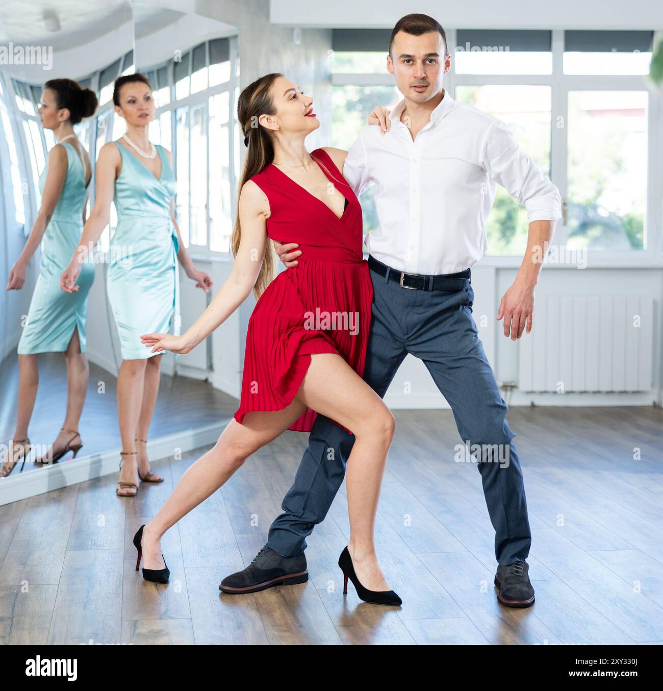 Couple in stage costumes learns tango dancing during individual lesson ...