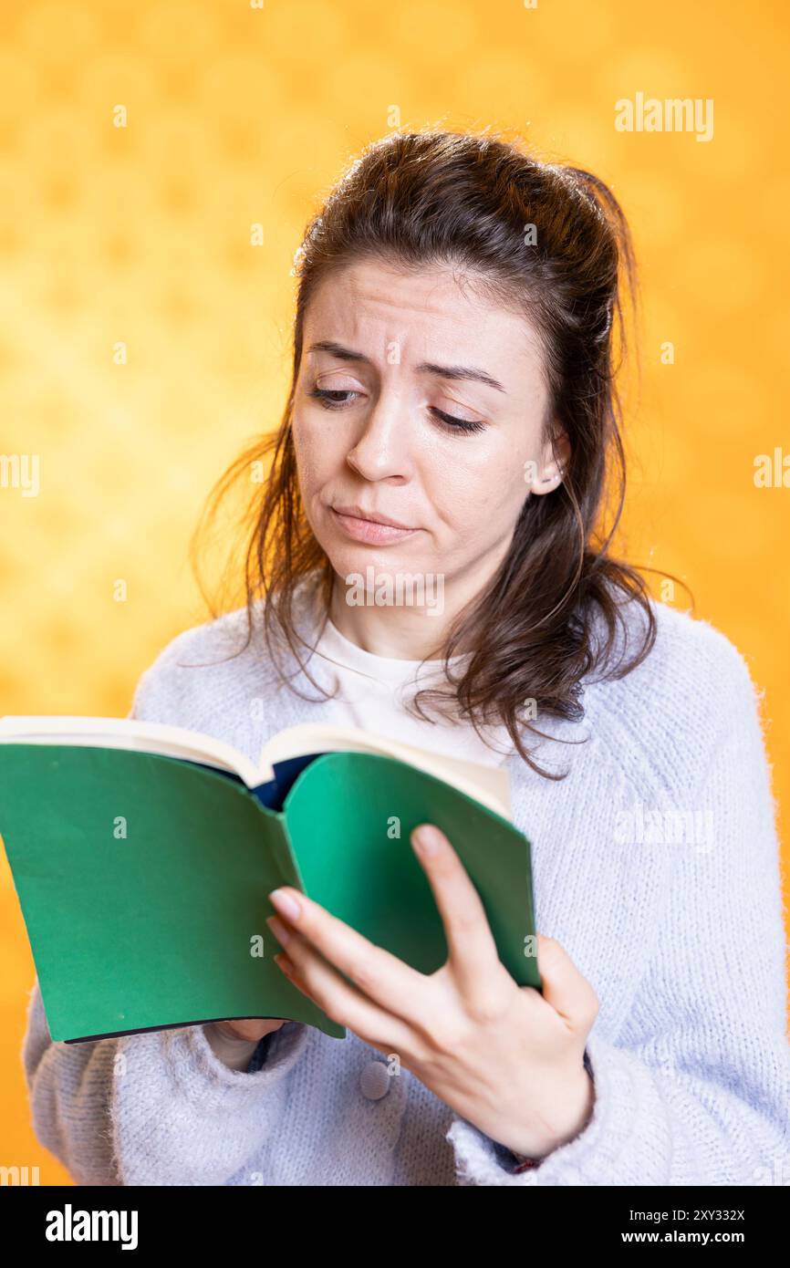 Woman frowning while gathering information for school exam in book ...
