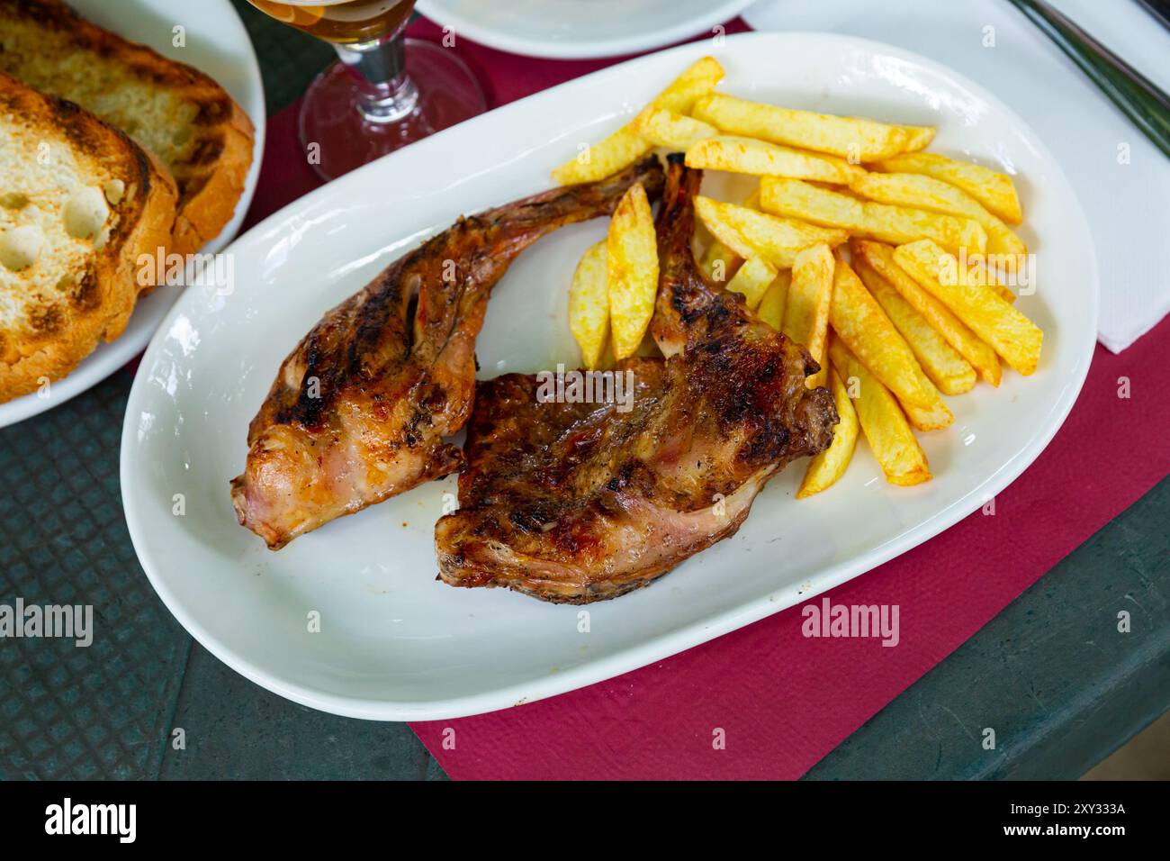 Fried rabbit legs with baked potatoes for dinner Stock Photo - Alamy