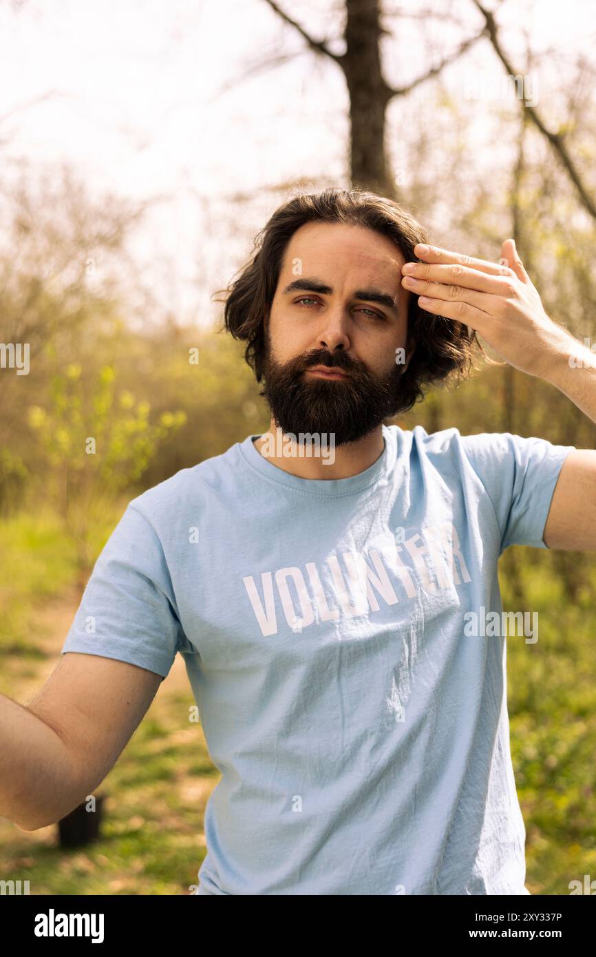 Portrait of sweaty tired male activist taking community service action ...