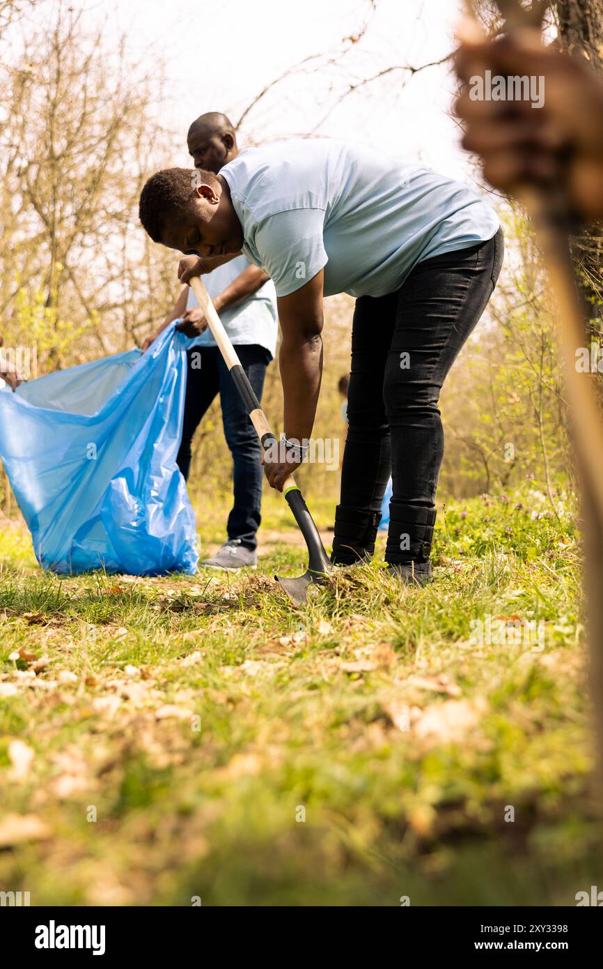 Diverse people using claw tools to grab garbage and plastic, storing it ...