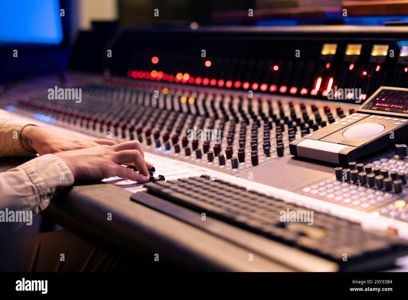 Audio engineer twisting pre amp knobs and switchers on panel board in ...