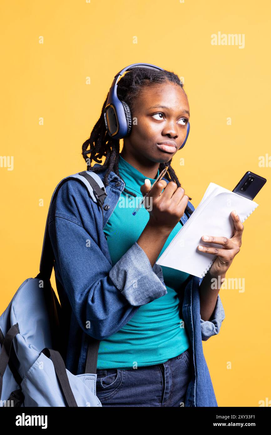African american student thinking how to write homework while listening ...