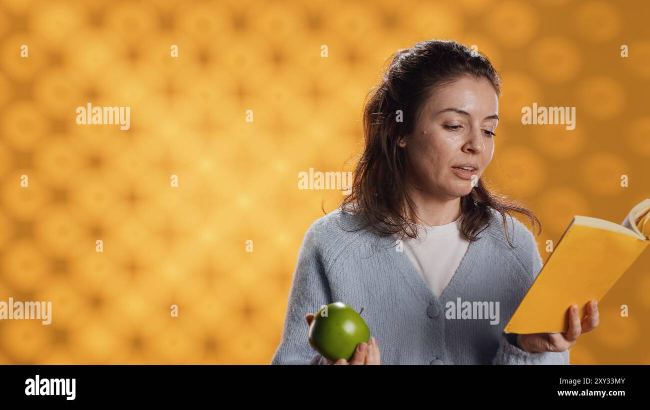 Woman reading book, throwing apple in air to exercise arm muscles ...