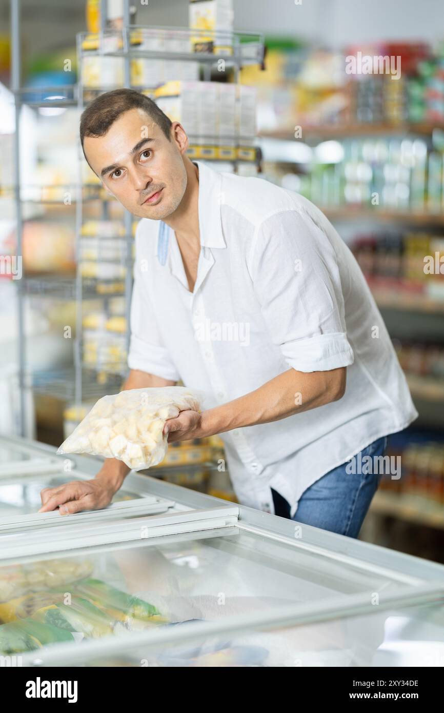 Young man choosing frozen food in store Stock Photo - Alamy