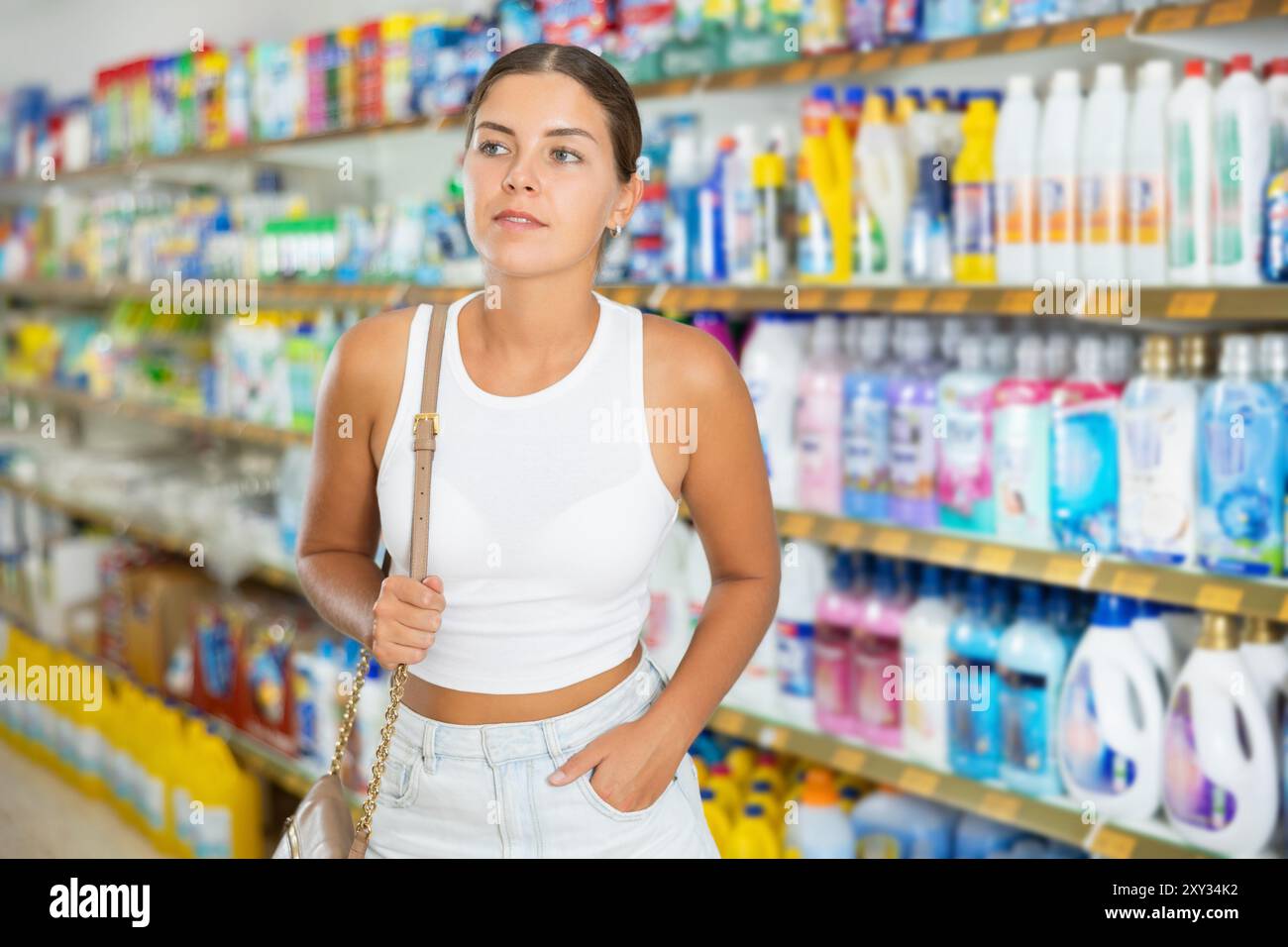 Young woman looking around in supermarket Stock Photo - Alamy