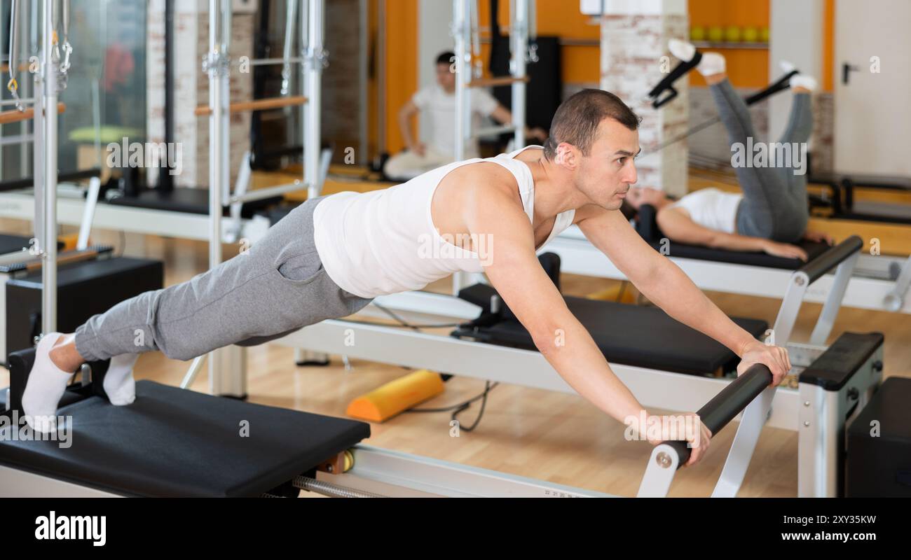 Man in different poses performs static and dynamic exercises on ...