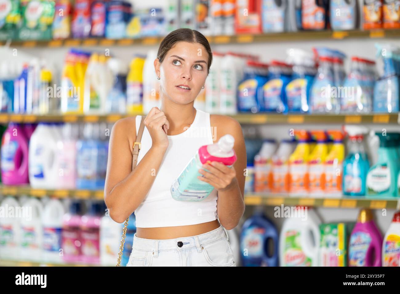 Woman carefully selects cleaning product in industrial section of ...