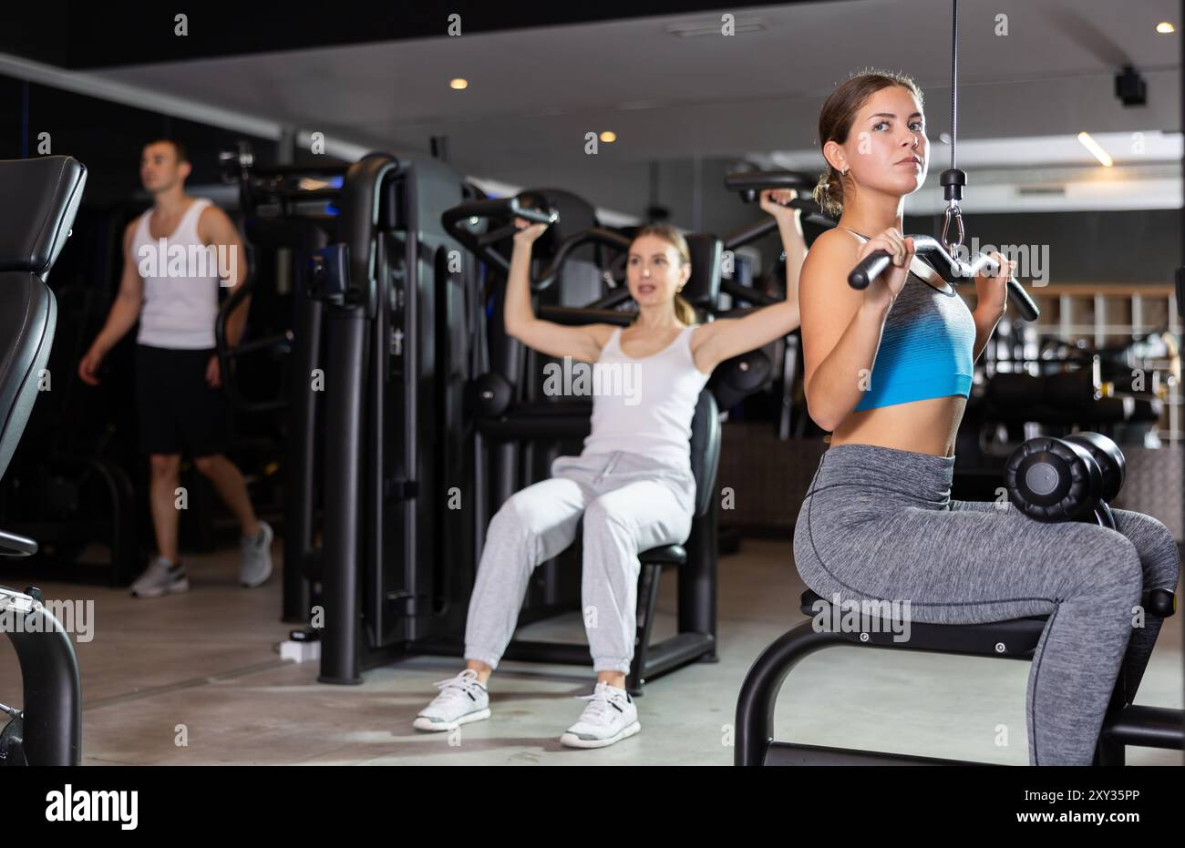 Slender athletic girl work out muscles of arms and shoulders on ...