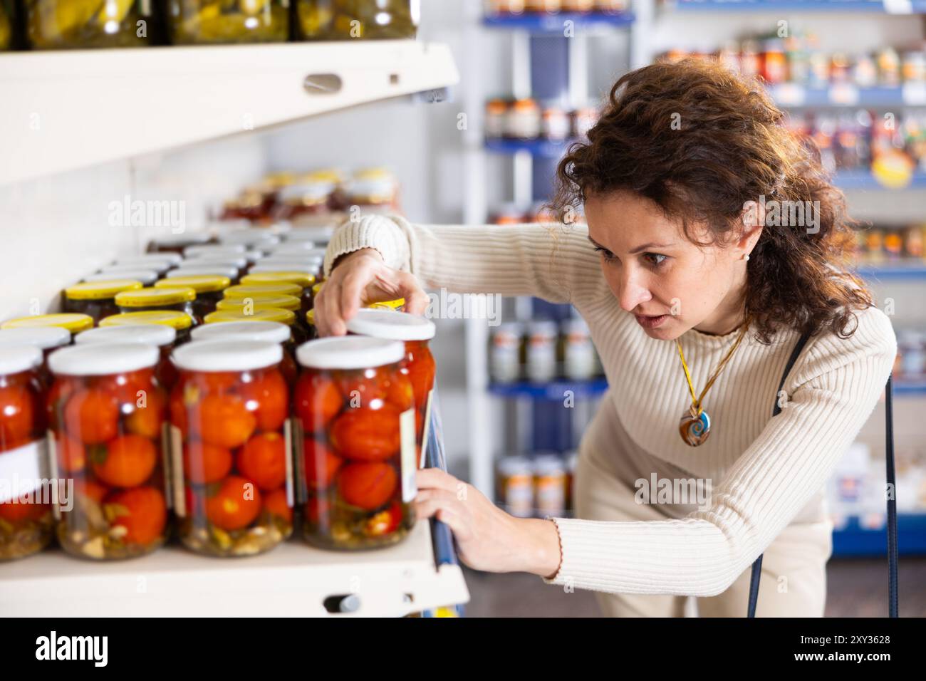 In Russian goods store, woman choose jar of pickled tomatoes Stock ...