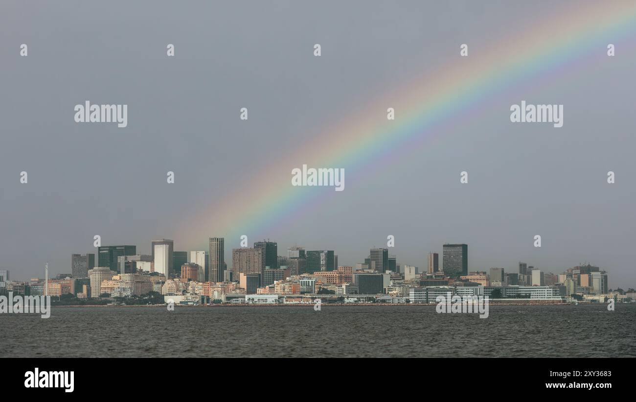 A vibrant rainbow arches over a sprawling urban skyline of Rio de ...