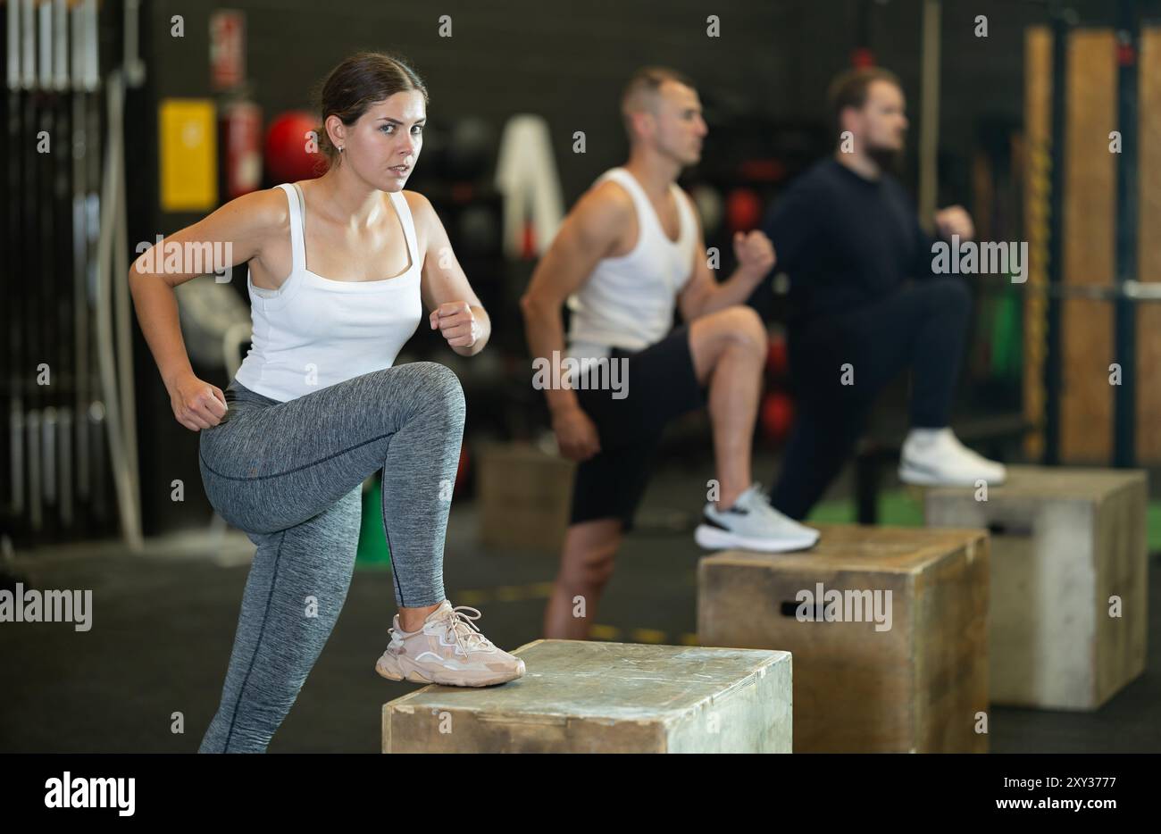 Sportive young girl doing step-up exercises with box during crossfit ...