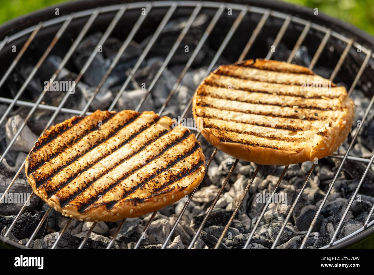 burger bread bun grilling on charcoal grill in the garden Stock Photo ...