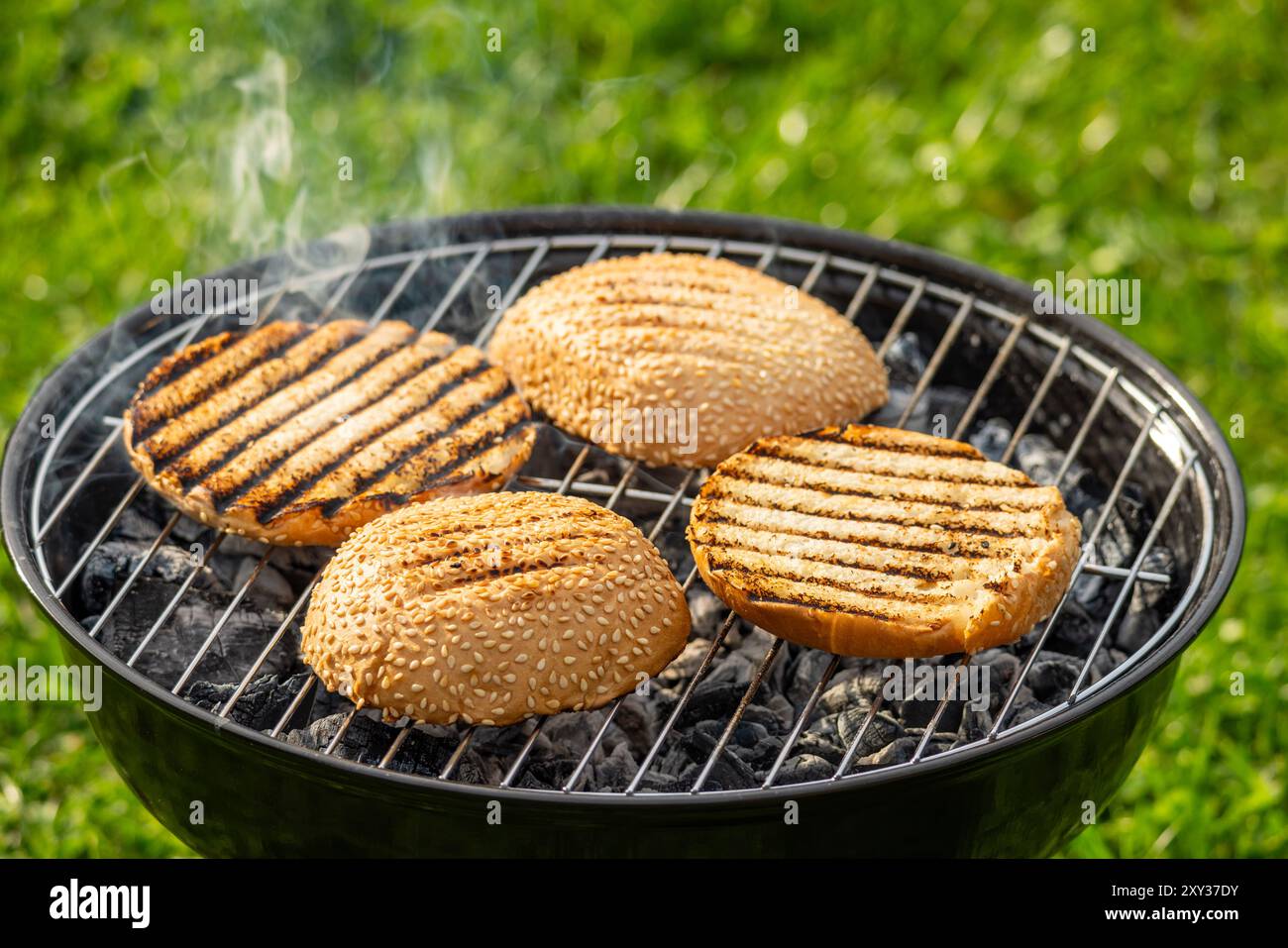 burger bread bun grilling on charcoal grill in the garden Stock Photo ...