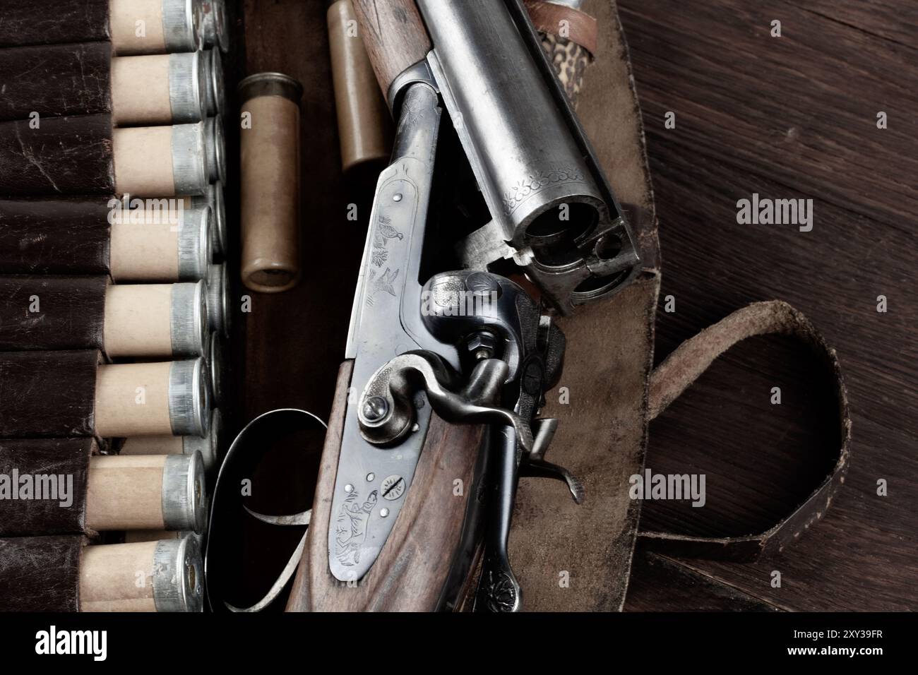 double barreled side shotgun with cartridges in bandolier on wooden ...
