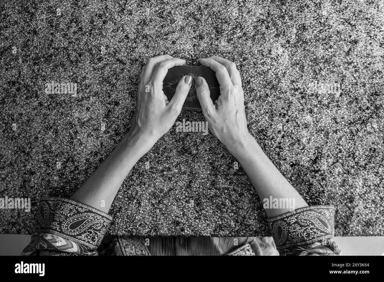 Top view of a tarot reader’s hands holding the deck of tarot cards ...