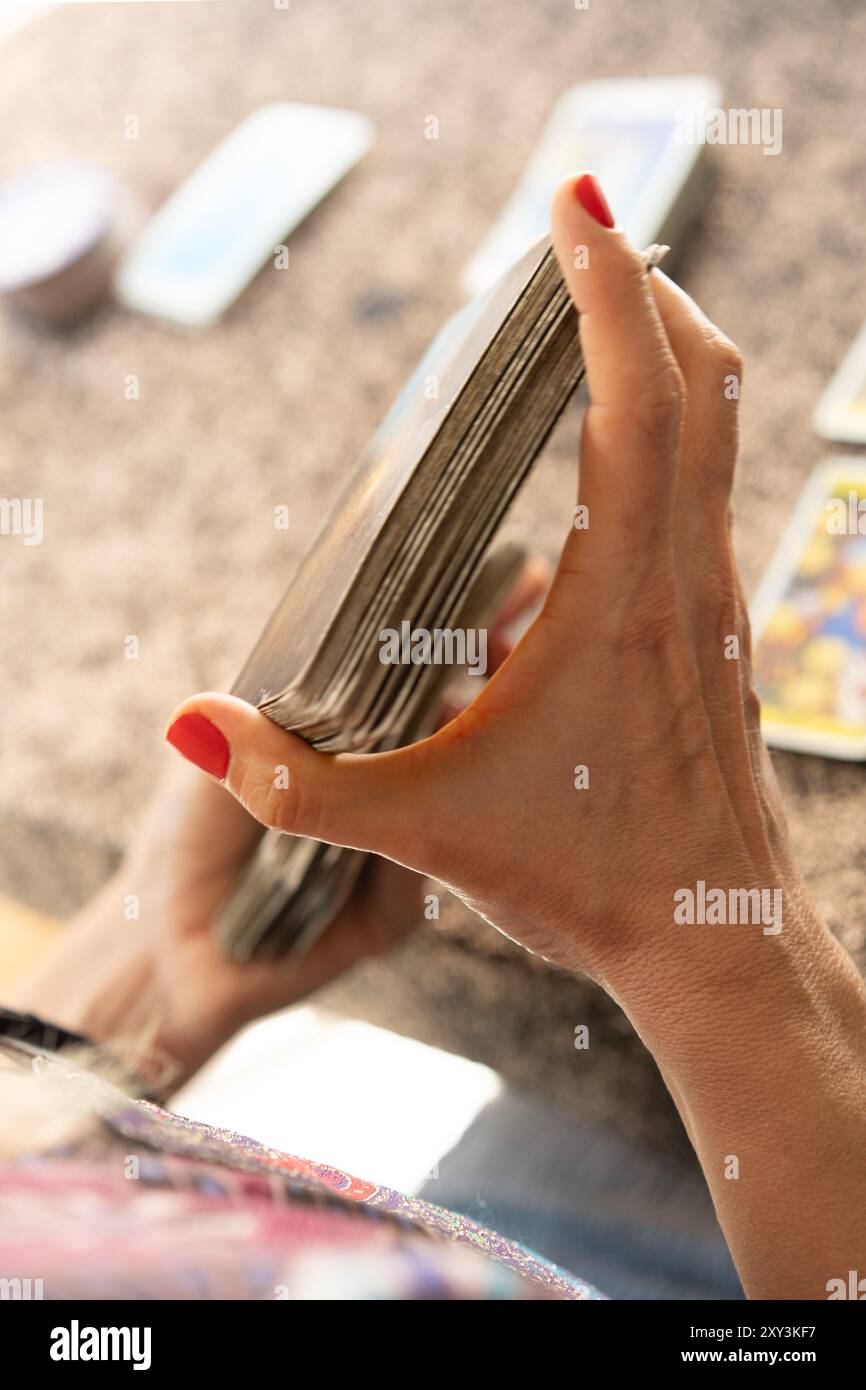 Over-the-shoulder perspective of a tarot reader skillfully mixing the ...