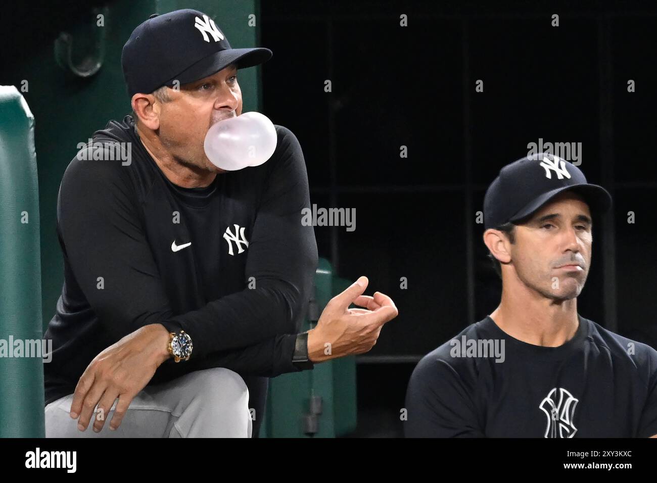 New York Yankees manager Aaron Boone, left, blows a bubble as he and ...