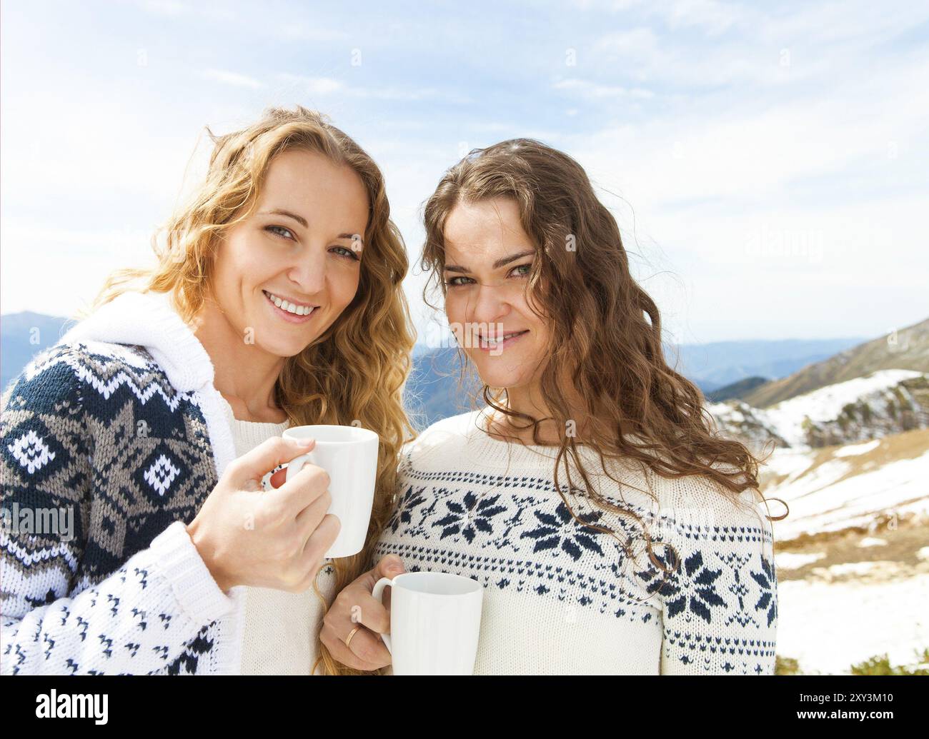 Two happy female friends enjoying hot drink In cafe at ski resort Stock ...