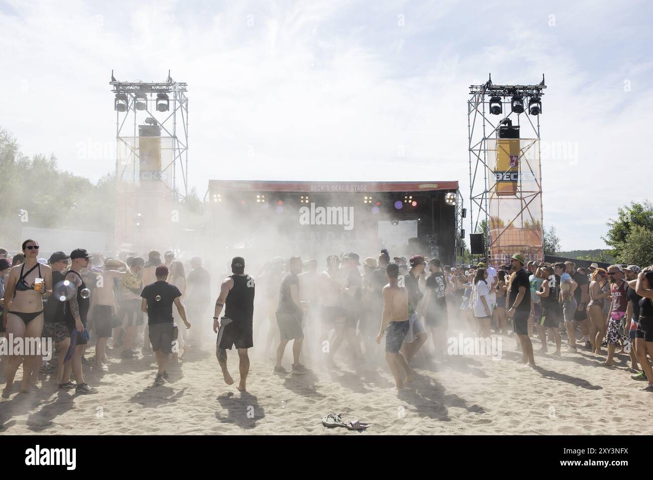 Festival visitors dance to the band Engst on the beach in front of the ...
