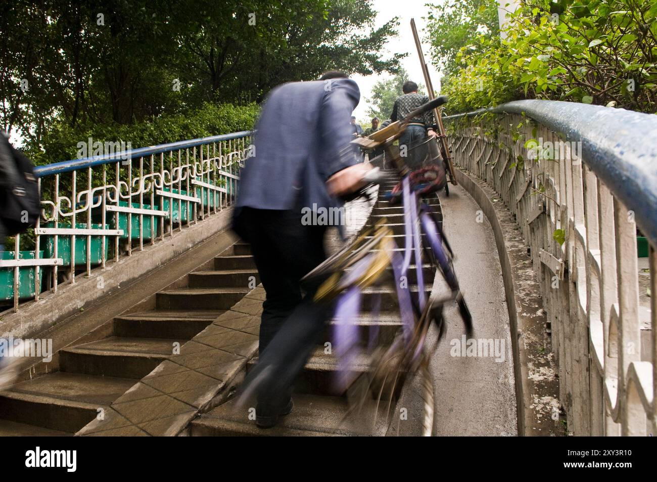 Pulling the bicycle on a pedestrian bridge in Guangzhou, China Stock ...