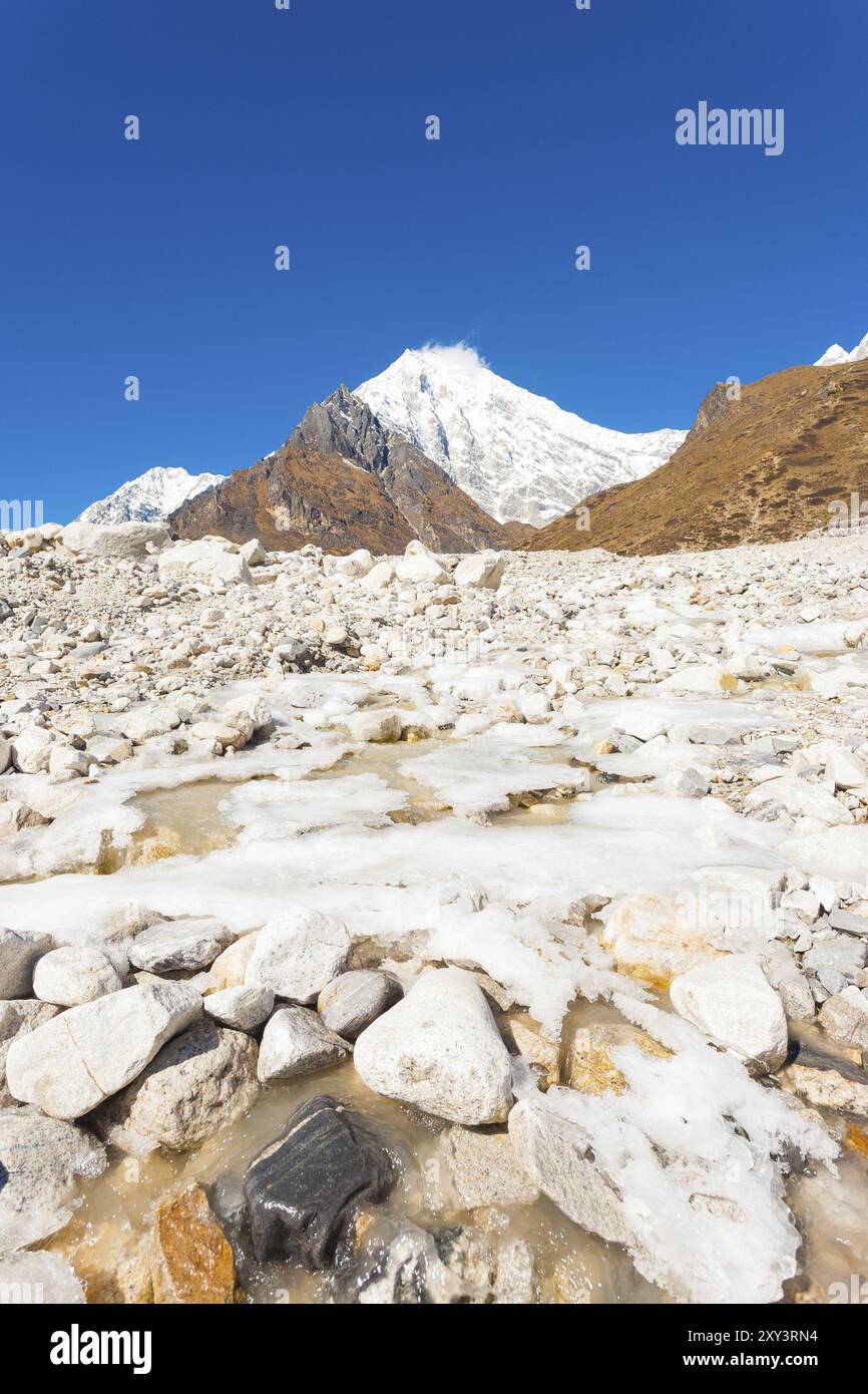 Icy alpine river running through white rocky terrain landscape at high ...