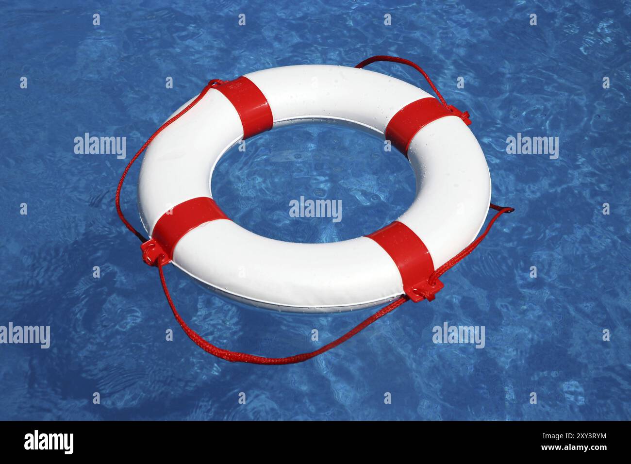 Red and white lifebuoy in a swimming pool, symbol for safety, rescue ...