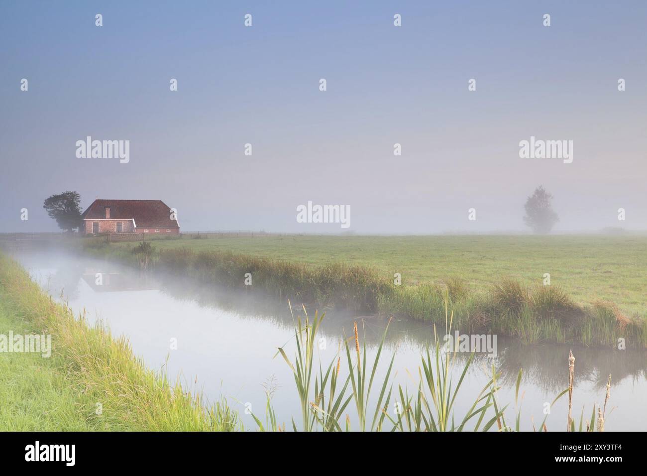 Farmhouse on riverside in morning fog during sunrise Stock Photo - Alamy