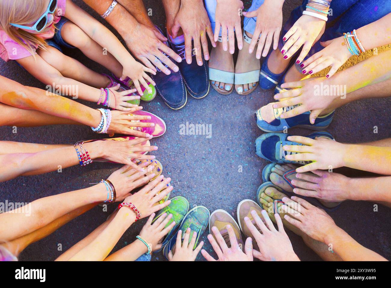 Friends putting their feet and hands together in a sign of unity and ...