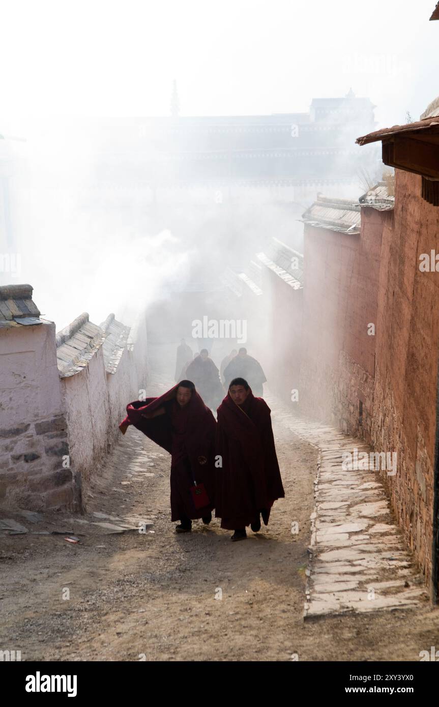 Tibetan Buddhist monks walking in the morning mist at the Labrang ...