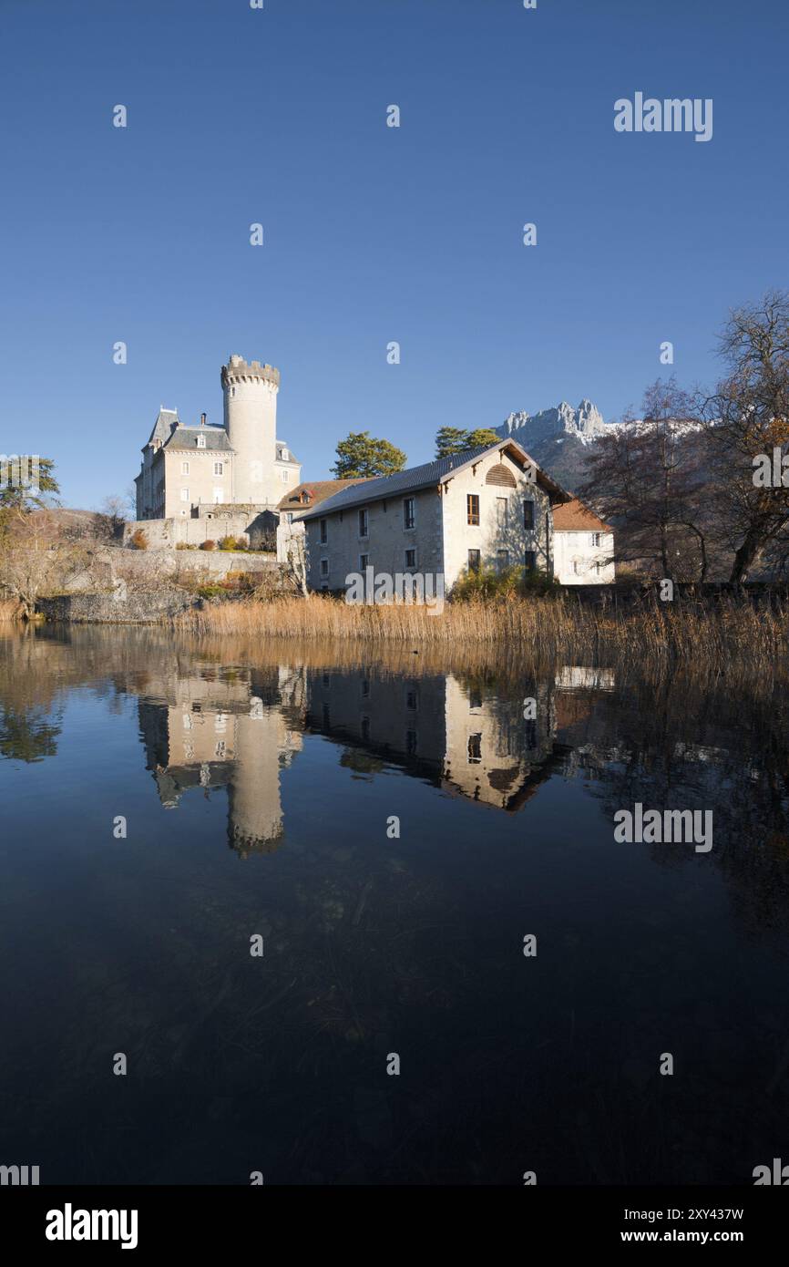 A medieval fairy tale castle at the foot of the French Alps reflected ...