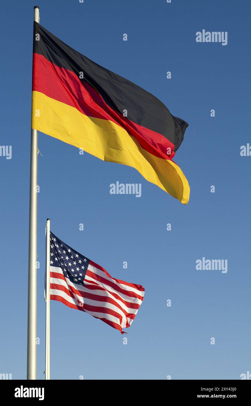 Flags of Germany and United States of America in front of blue sky ...