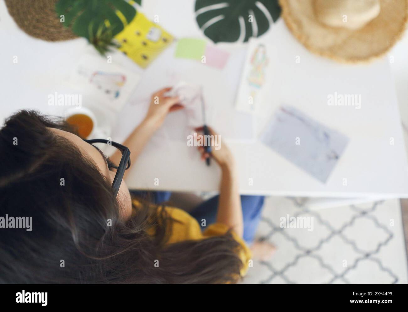 Young brunette woman creating her Feng Shui wish map using scissors ...