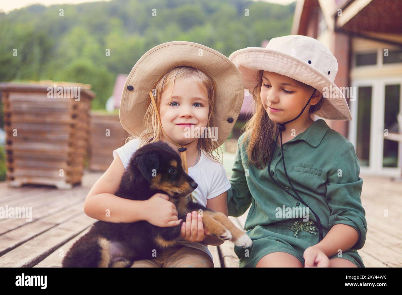 Two cute little sisters hugging dog puppy. Friendship and care concept ...
