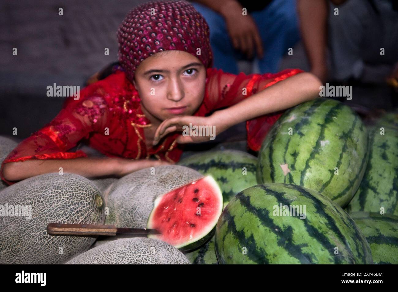 An Uyghur girl selling Hami melons and watermelons in the old city of ...